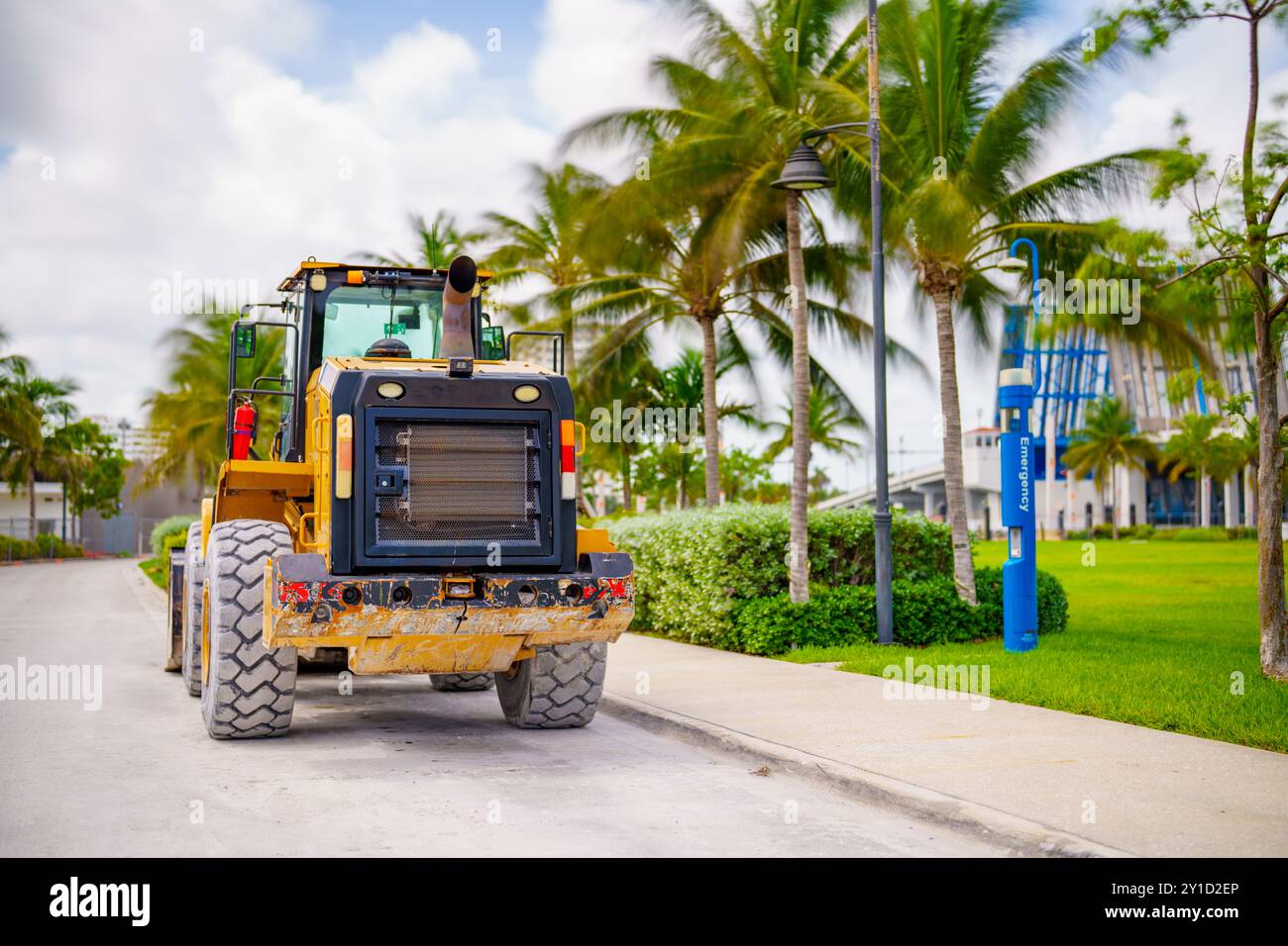 Wheel loader by a park with palms Stock Photo - Alamy