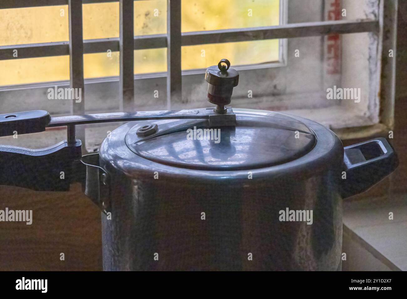 Steam escaping from the pressure cooker's lid in the kitchen. Pressure ...