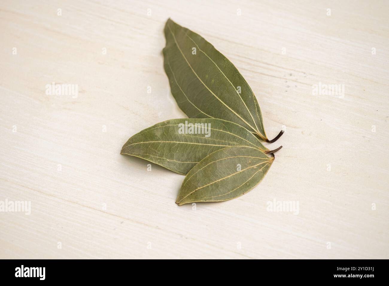 Dried bay leaves (Laurus nobilis) isolated on wooden background. It is ...