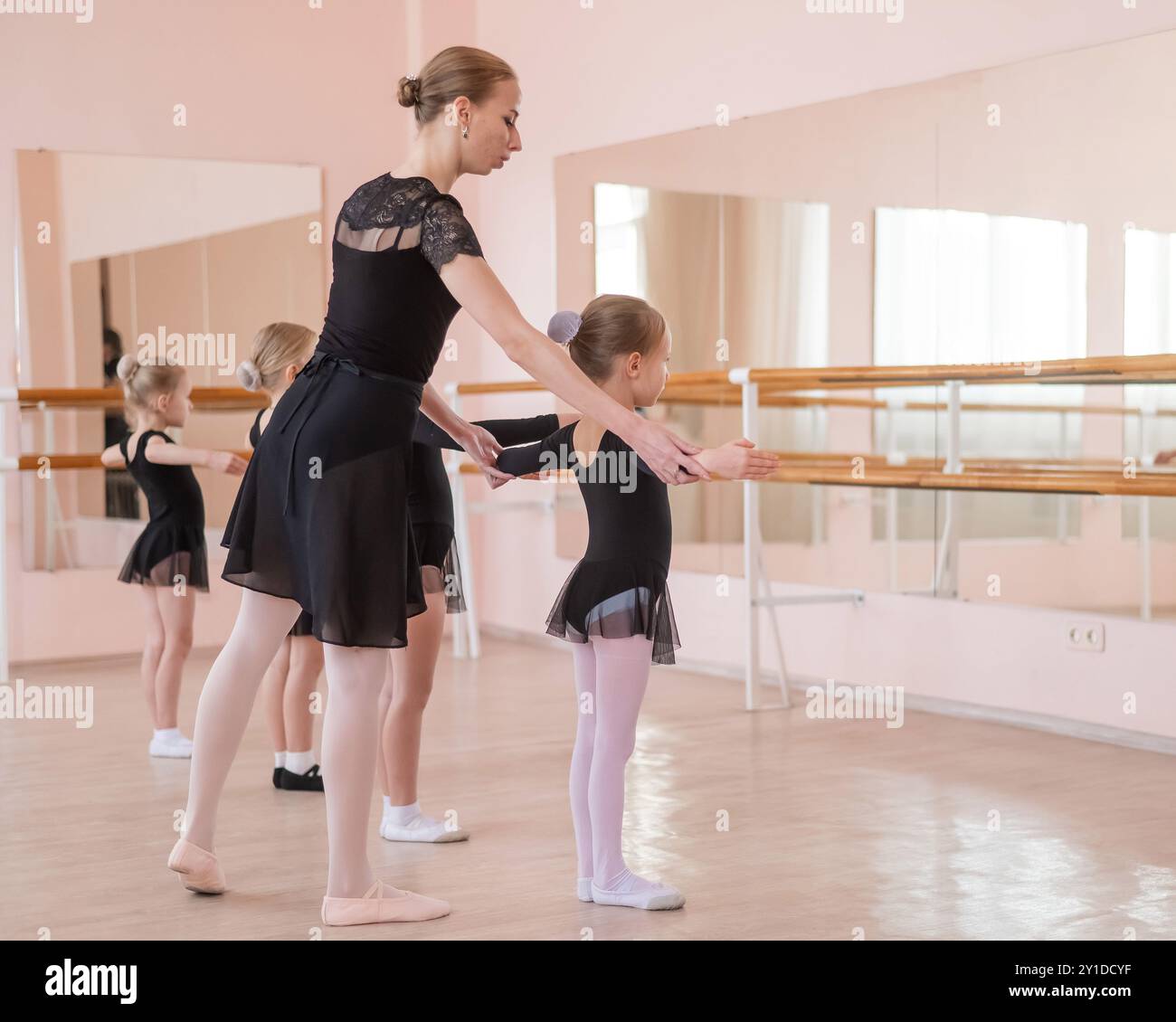 Children's ballet school. Caucasian woman teaching ballet to little ...