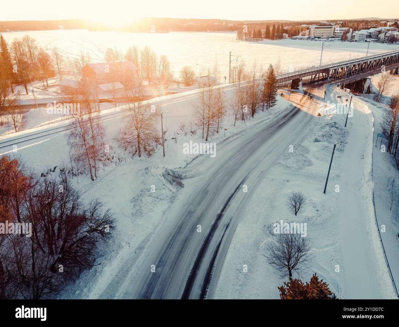 Aerial view of the sun over snowy railway line in Rovaniemi, Lapland ...