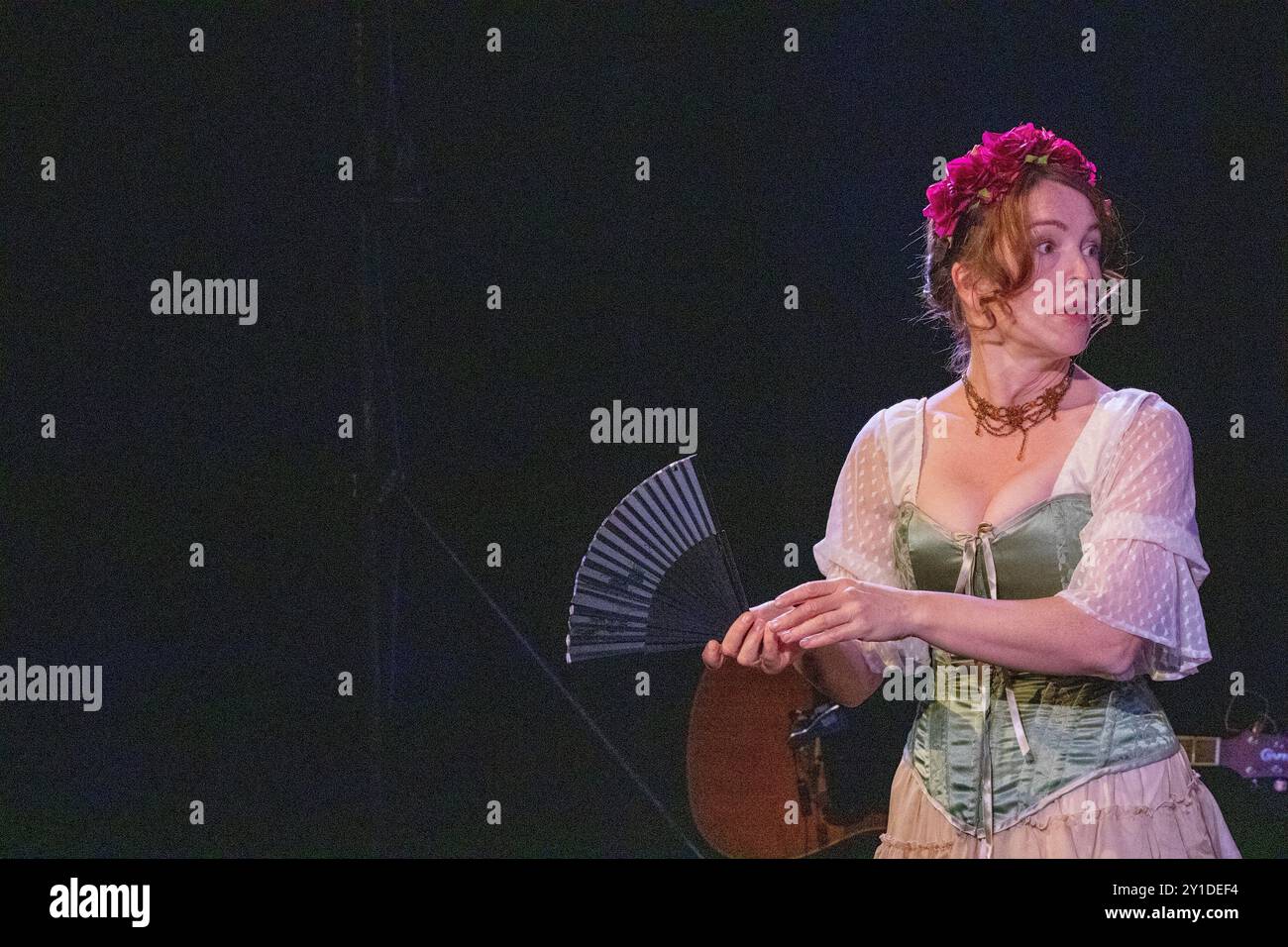 A attractive actress in a red floral headdress and green bustier ...