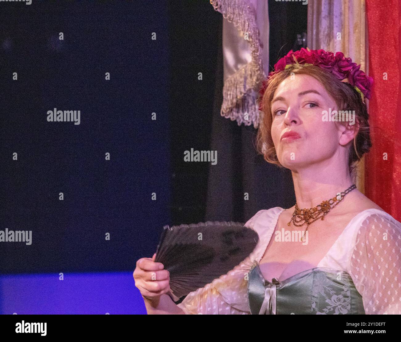 A attractive actress in a red floral headdress and green bustier ...