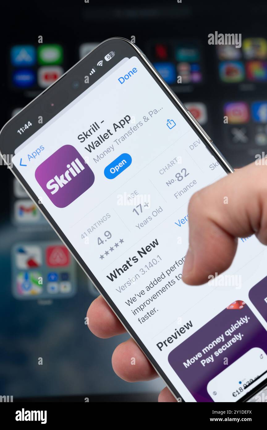 New York, USA - August 5, 2024: Smartphone in hand with Skrill app on screen macro close up view ...