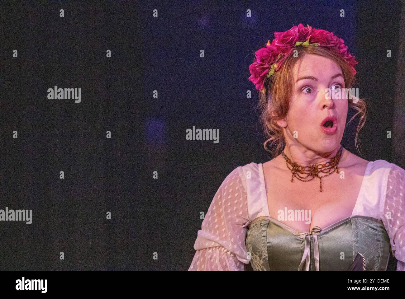 A attractive actress in a red floral headdress and green bustier ...