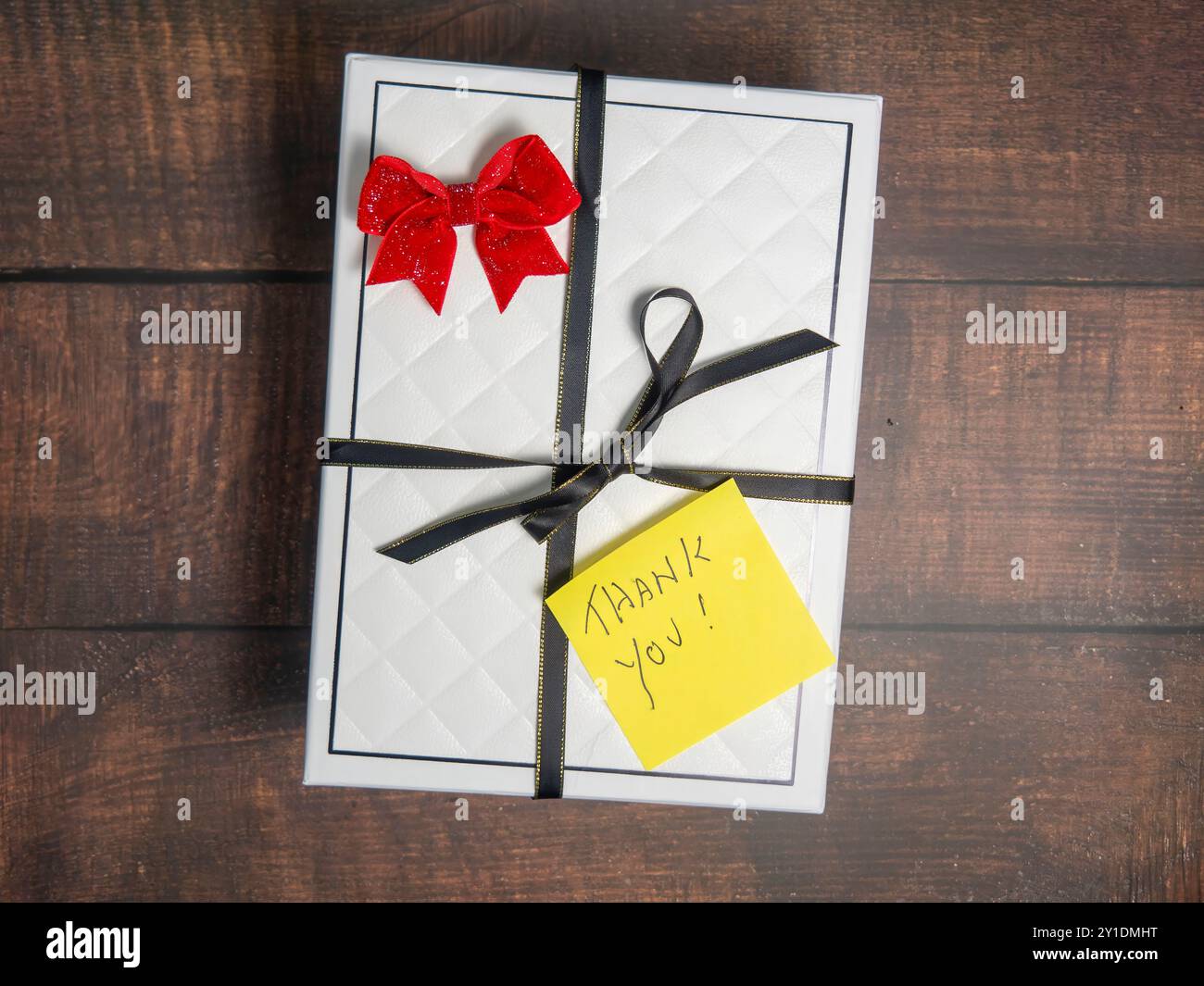Yellow Thank You Post-it Note on a white gift box with red bow and ...