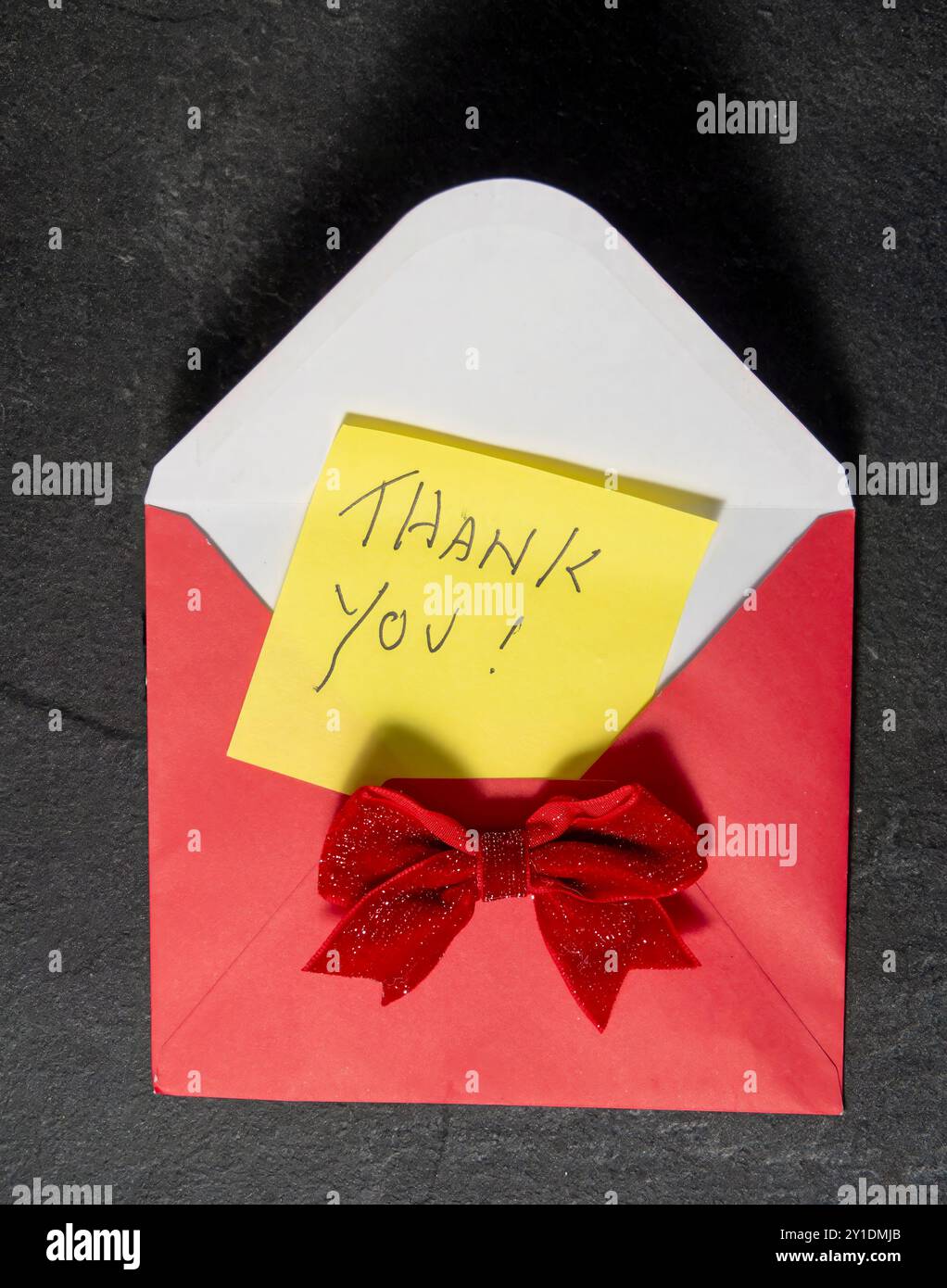 Yellow Thank You Post-it Note on a red envelope and red bow on a slate ...