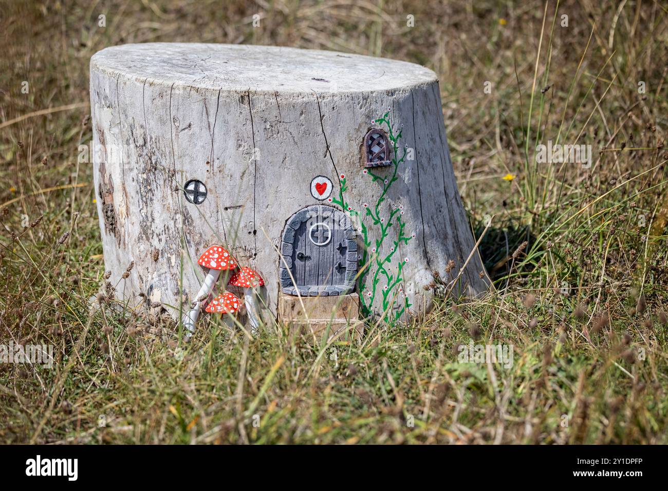 Miniature fairy house made from tree stump in field at Northam Burrows ...