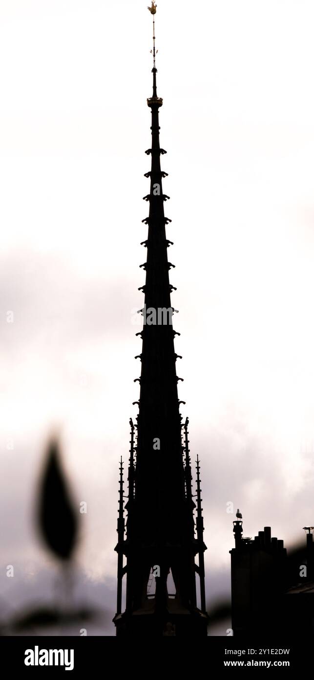 A spire rises into the cloudy sky, a silent silhouette reaching for the ...