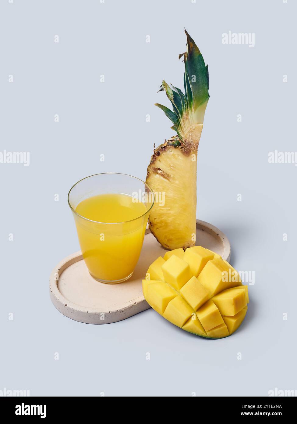 Tropical fruits variety with ananas and a glass of juice on a grey ...