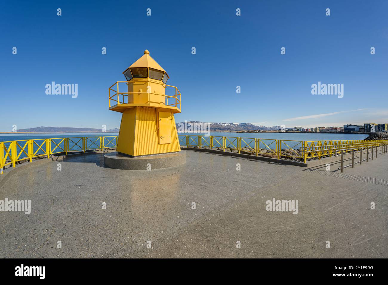 The historic yellow Hofoi lighthouse on the rocky shore of Reykjavik ...
