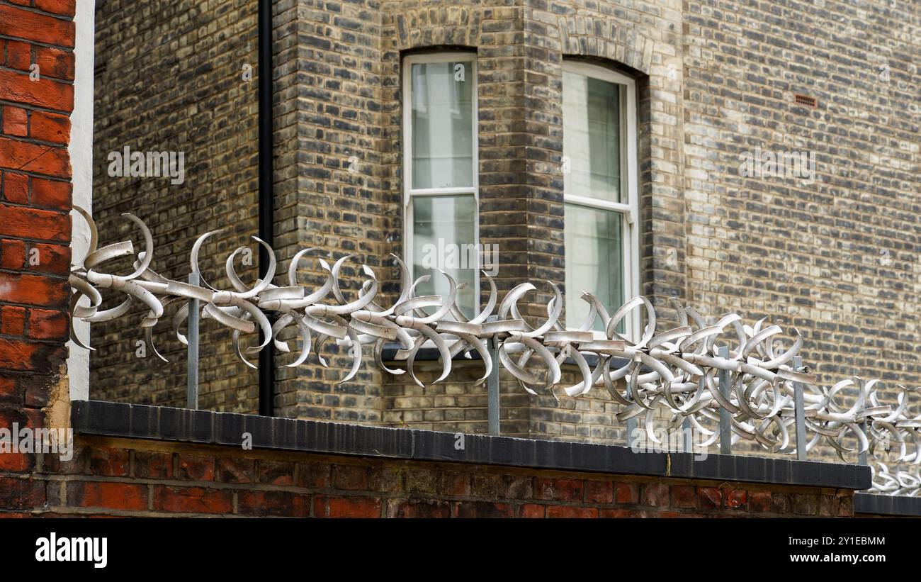 selective focus on a brick security wall with a spinning metal anti ...