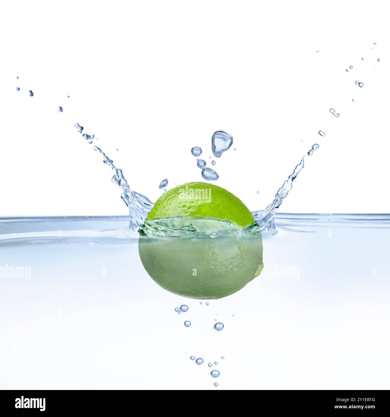 Fresh lime falling into water against white background Stock Photo - Alamy