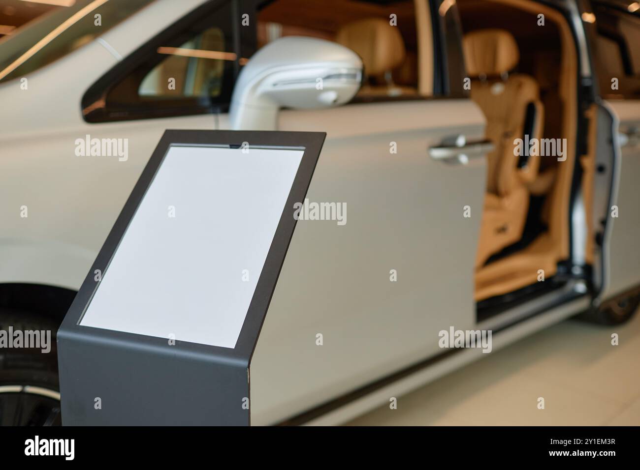 Car dealership information stand with blank mockup sheet displaying vehicle specifications in ...