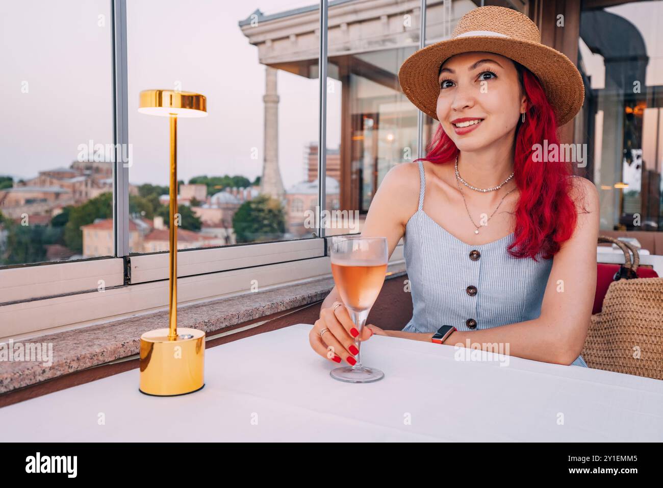 An elegant dining table with a woman raising her glass of amber wine ...