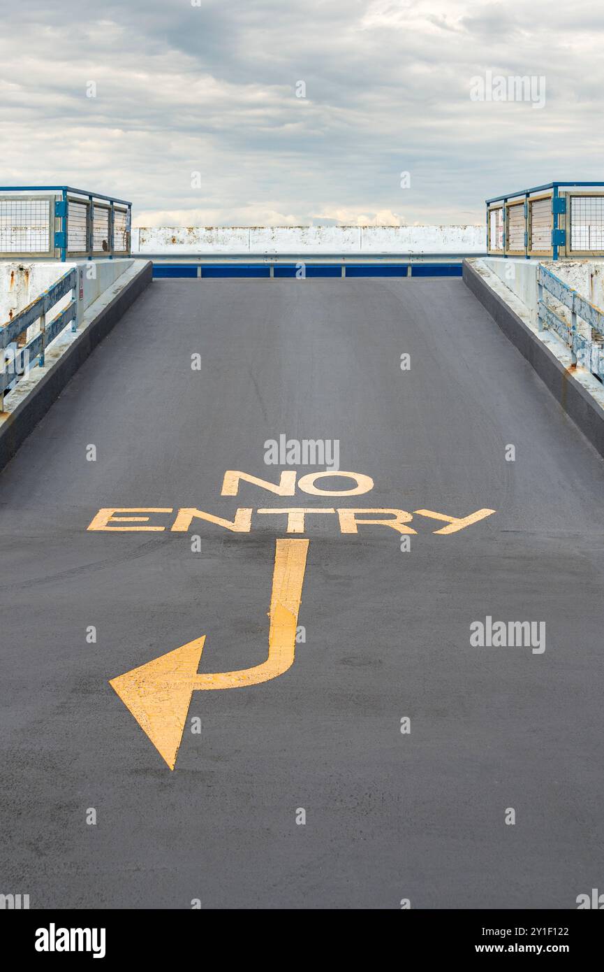 yellow no entry and left turn arrow painted on a car park road Stock ...