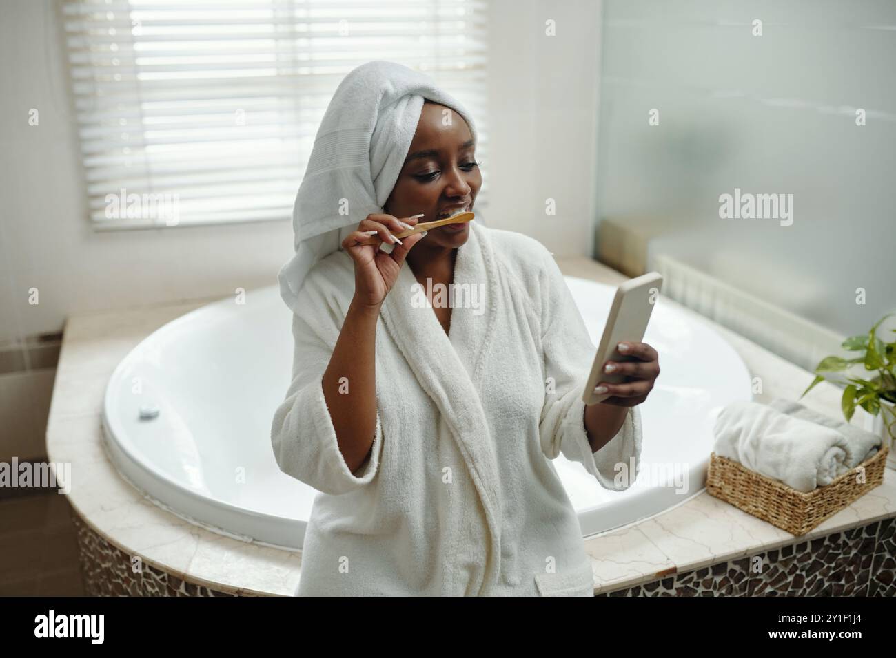 Brushing Teeth While using Smartphone in Bathroom Stock Photo - Alamy