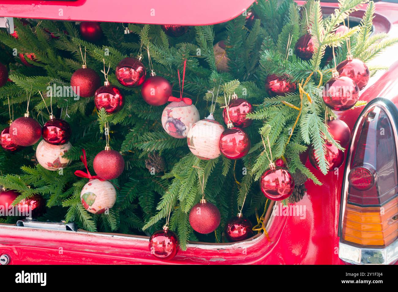An opened red car trunk filled with cloth bags full of gifts and ...