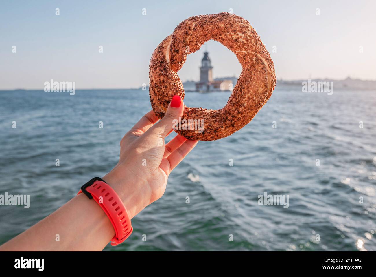 A picturesque view of the Bosphorus with a girl savoring her simit ...