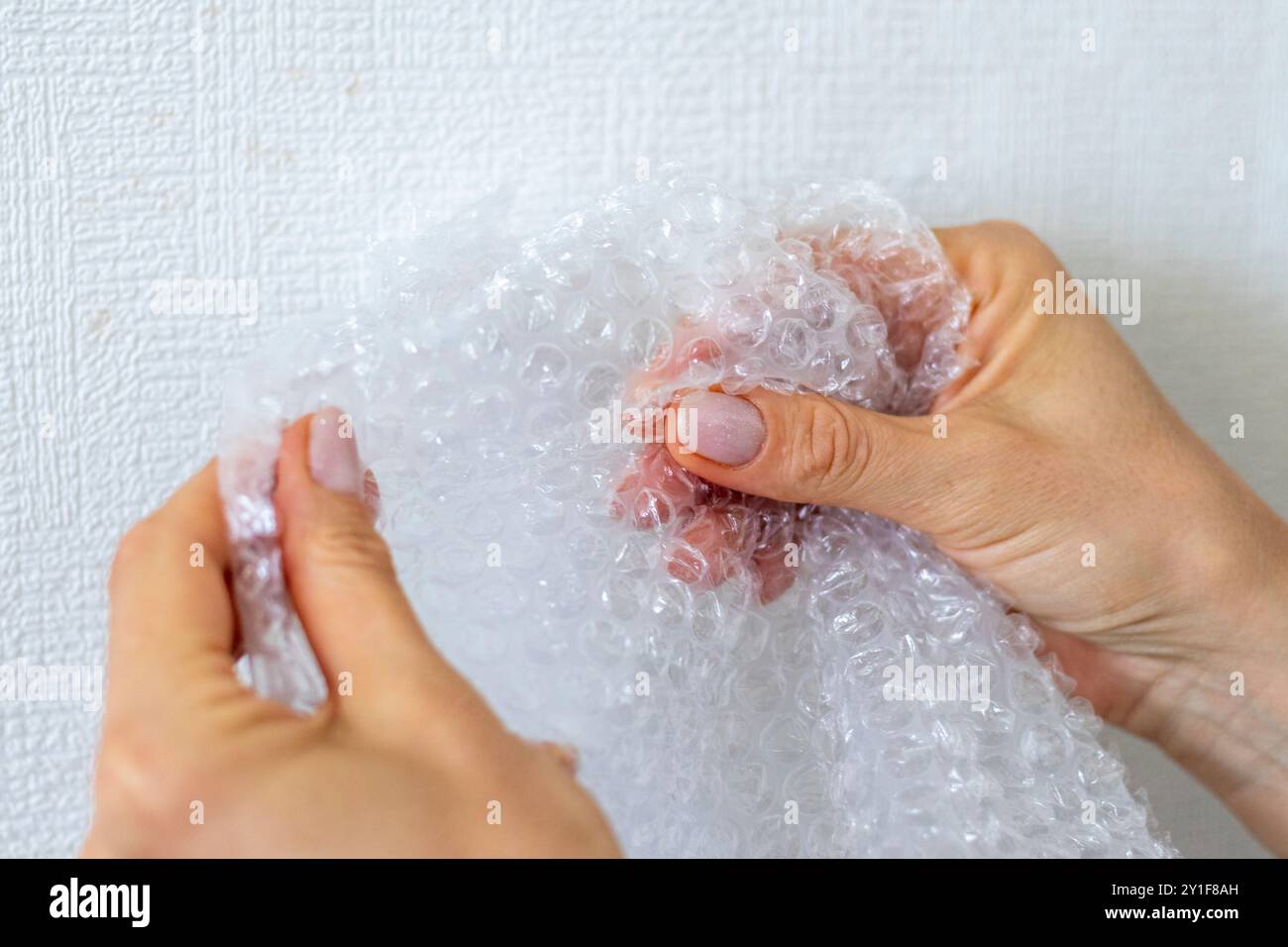 Shot of the woman bursts bubble wrap Stock Photo - Alamy