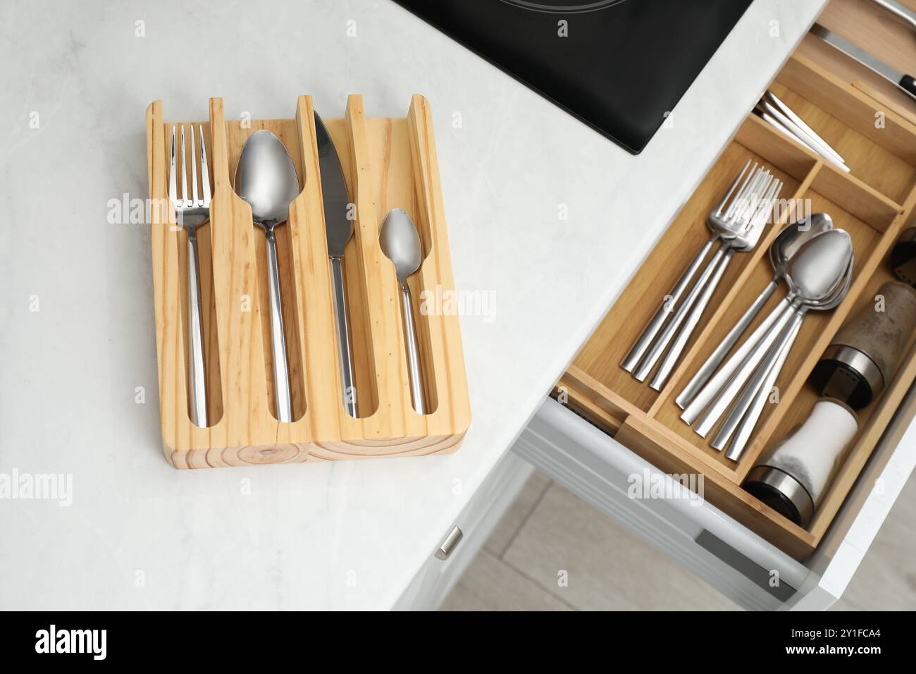 Set of cutlery on counter and other utensils in kitchen drawer Stock ...