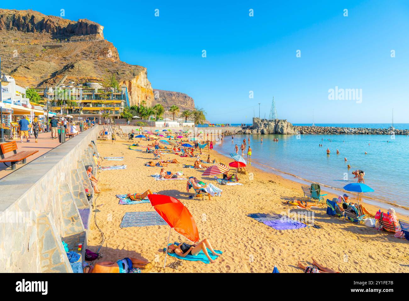 A sunny day at the Playa Mogan sandy beach and promenade of cafes at ...