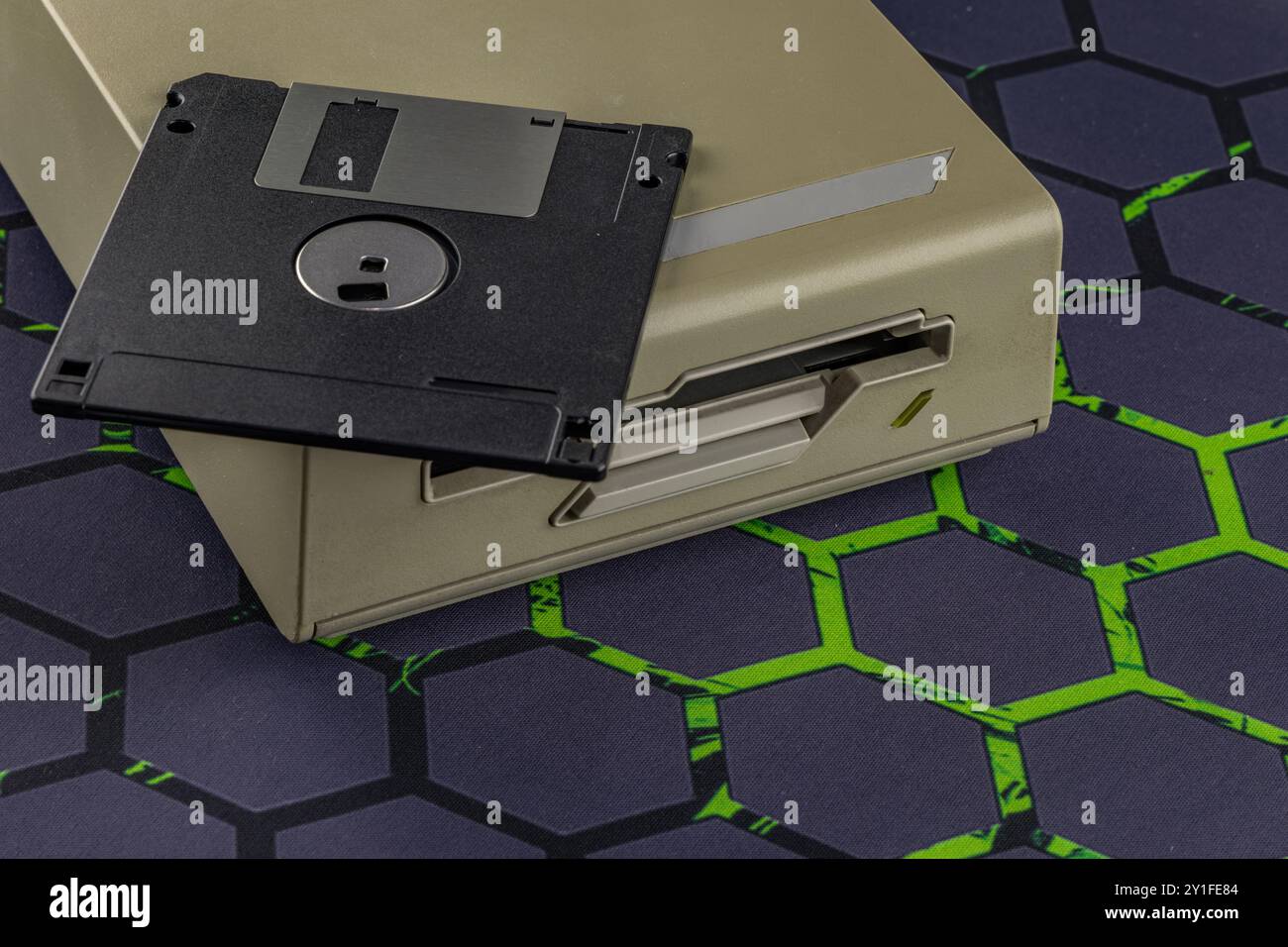 Old damaged 3.5 inch floppy disk drive, colorful floppy disks arranged on a mouse and keyboard ...