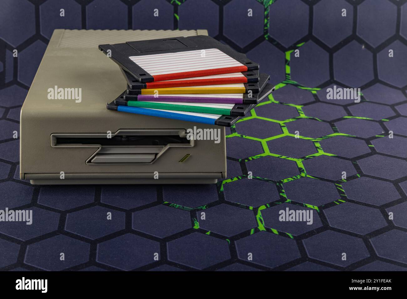 Old damaged 3.5 inch floppy disk drive, colorful floppy disks arranged ...