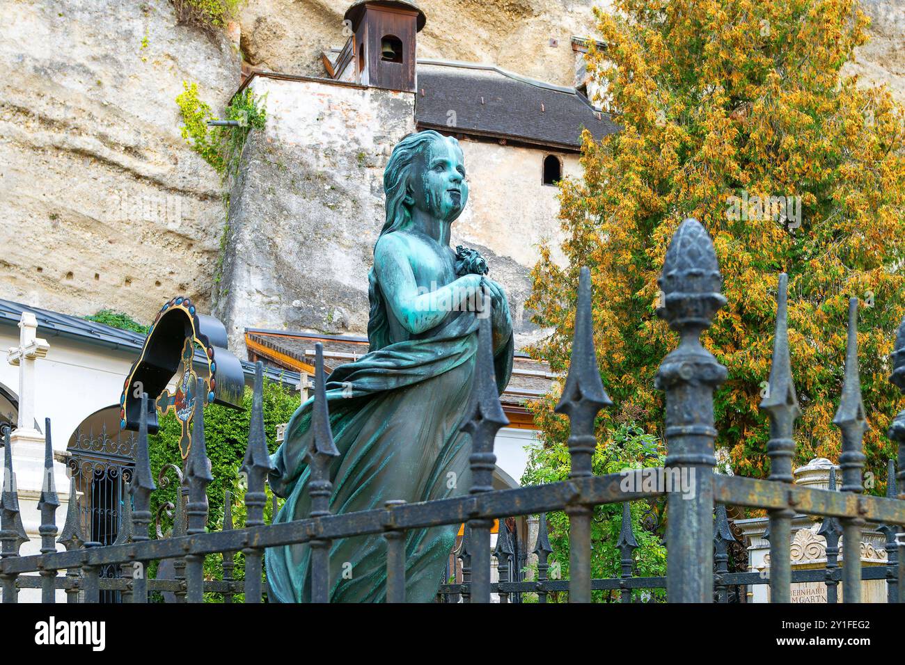 Bronze statue of a young girl as a memorial headstone at a grave in the ...