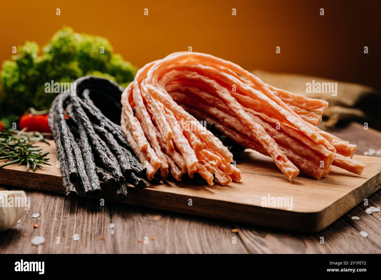 Variety of black and light meat sticks on board with herbs and spices ...