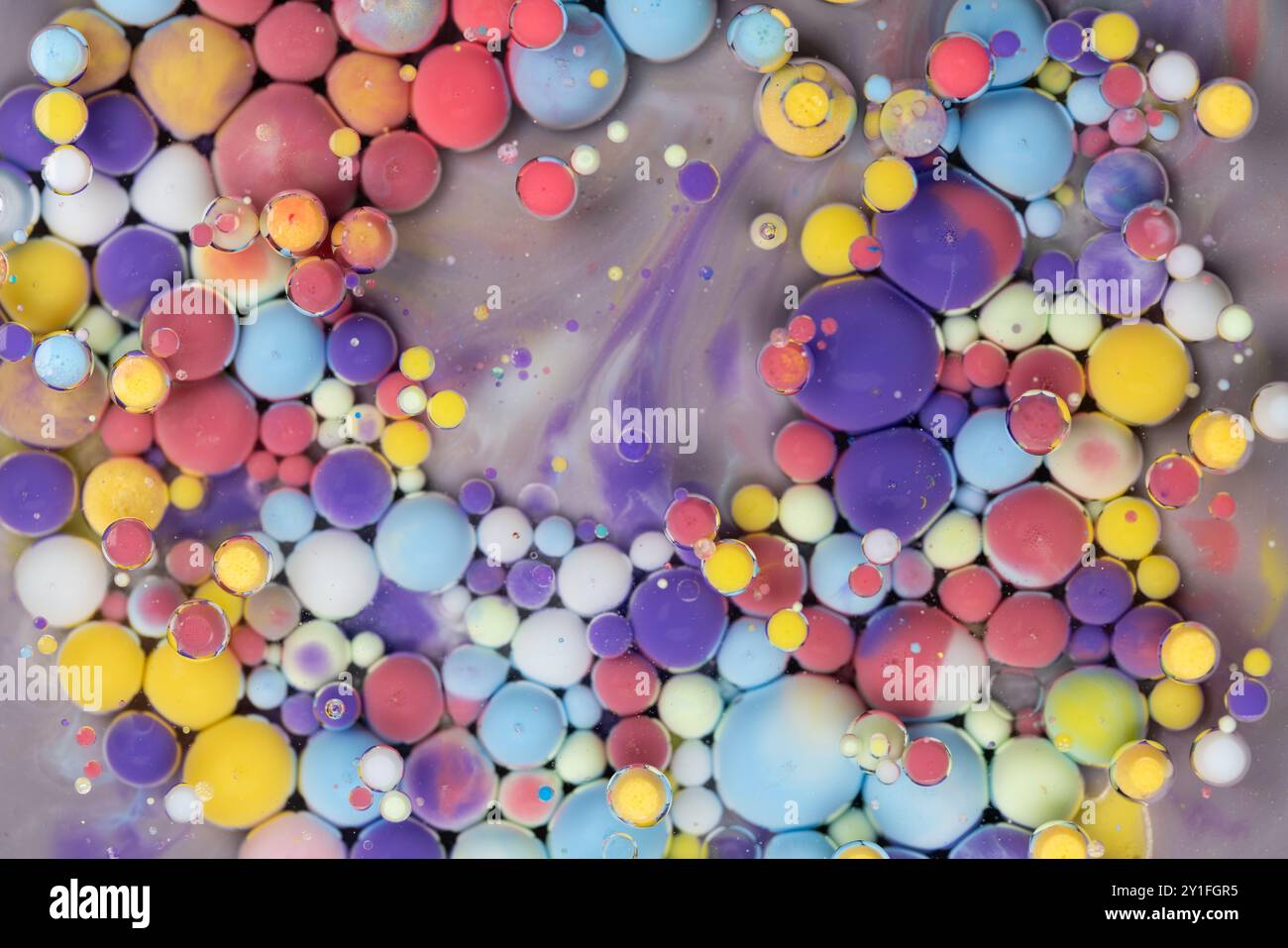 Colorful abstract arrangement of floating paint droplets on a surface ...