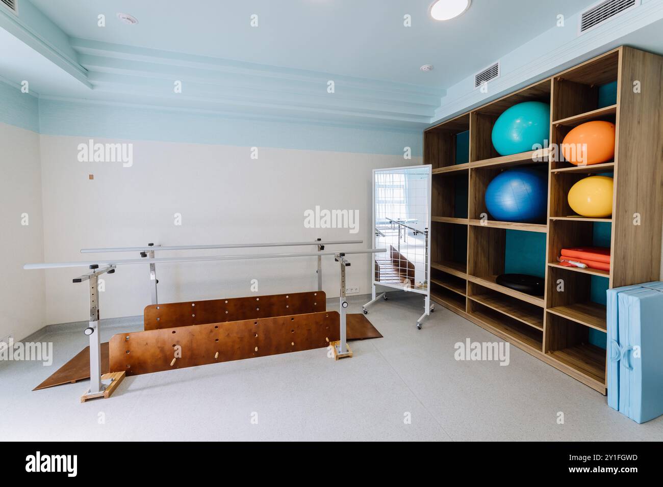 Rehabilitation equipment room with parallel bars and exercise balls for ...