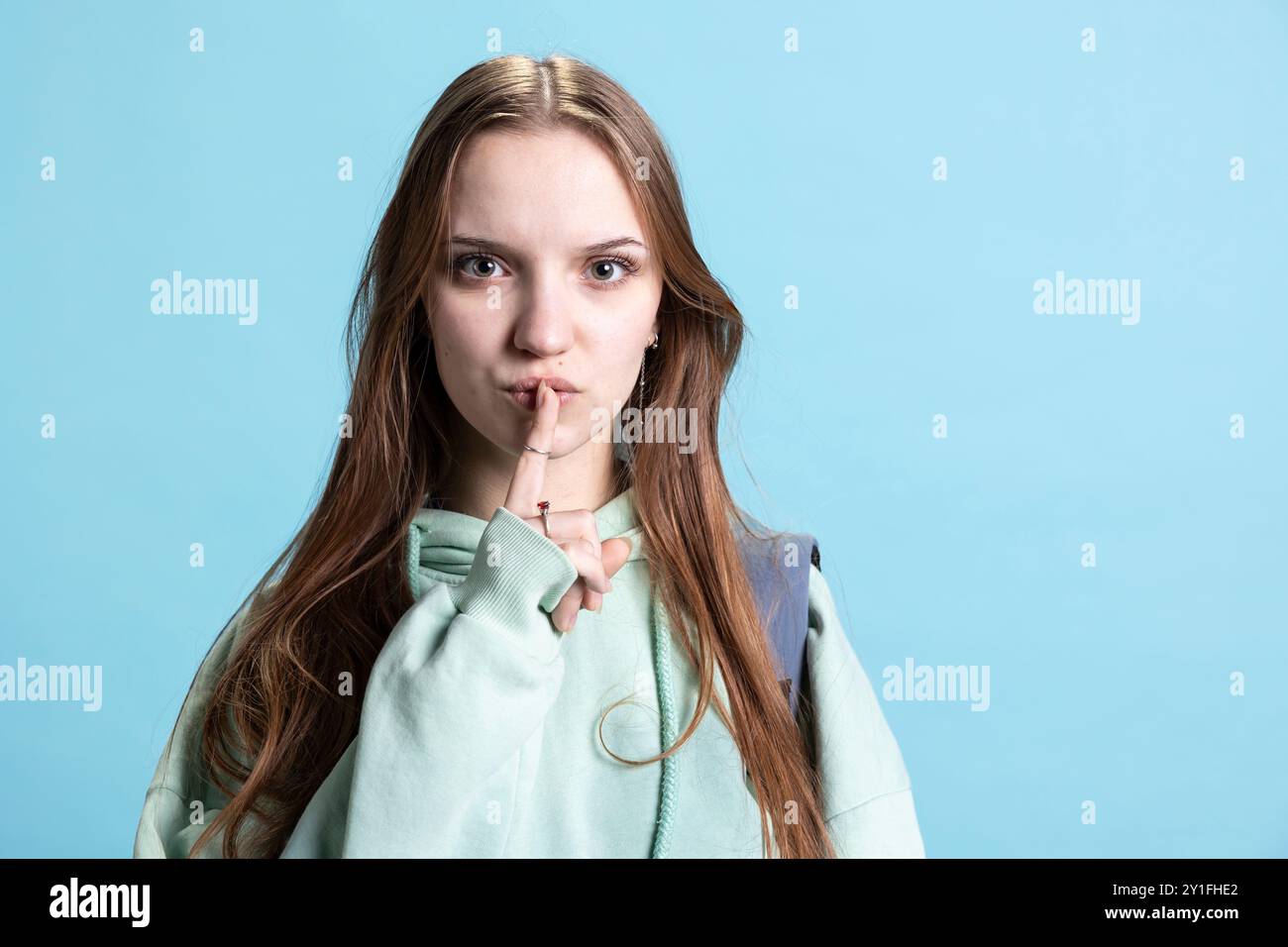 Upset young teenager doing shushing hand gesturing, irritated by loud ...