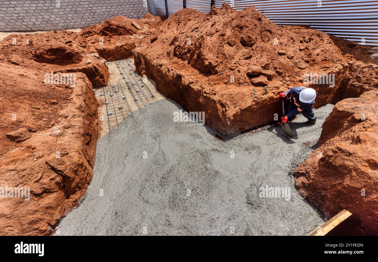 african construction worker with a shovel in liquid concrete Stock ...