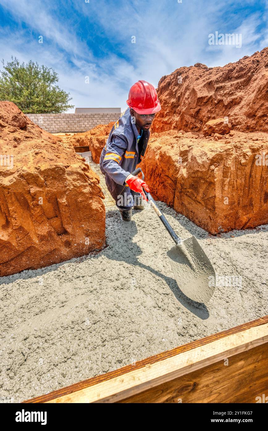 african construction worker with a shovel in liquid concrete Stock ...