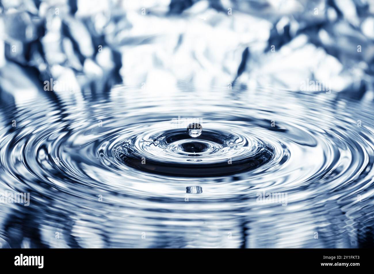 a drop of water falls onto the water surface and creates concentric ...