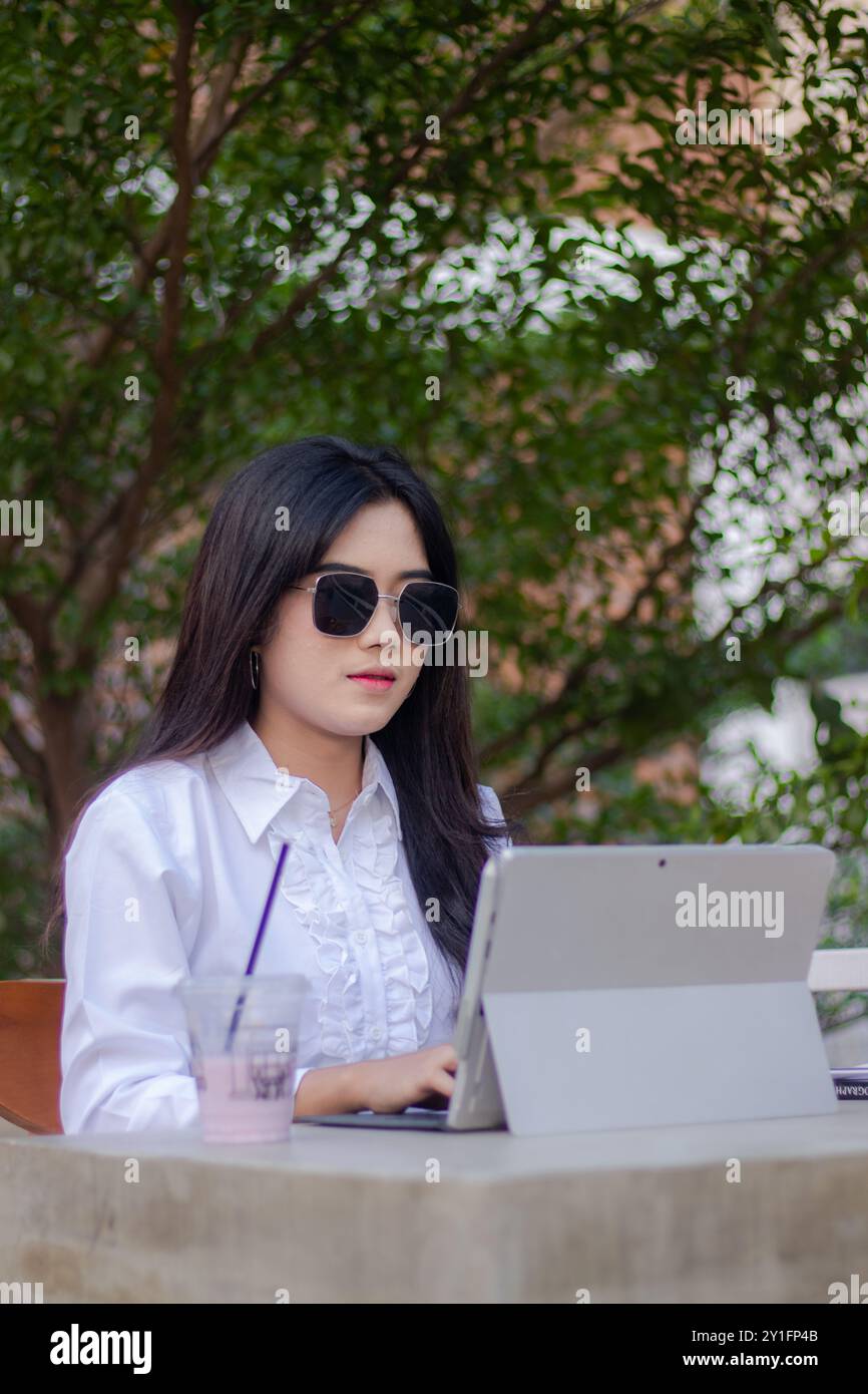 office beautiful asian woman in outdoor cafe. Elegant girl doing work ...