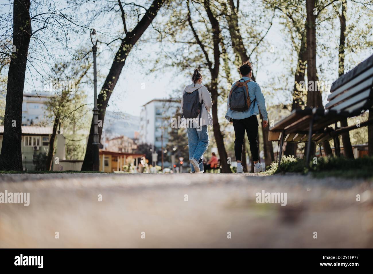 Two students walking together on a sunny campus pathway Stock Photo - Alamy