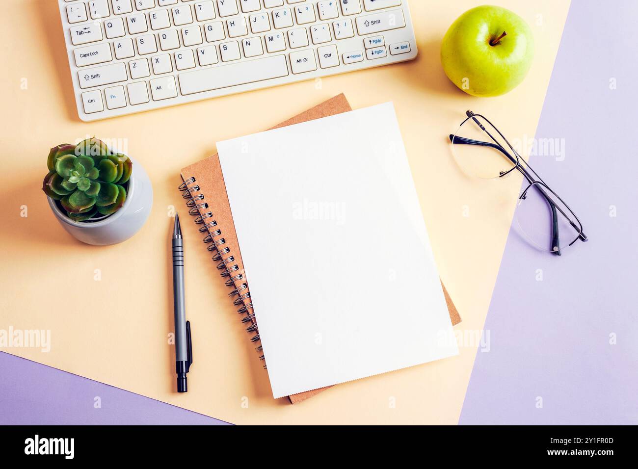 Desktop with blank paper, notepad, computer keyboard, glasses and green ...