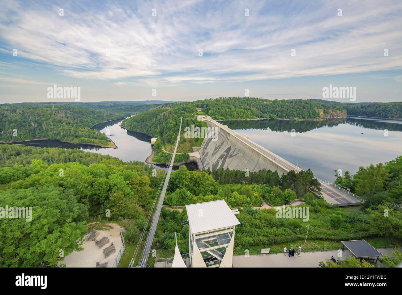 Expansive view of a dam and bridge spanning a river and green forests ...