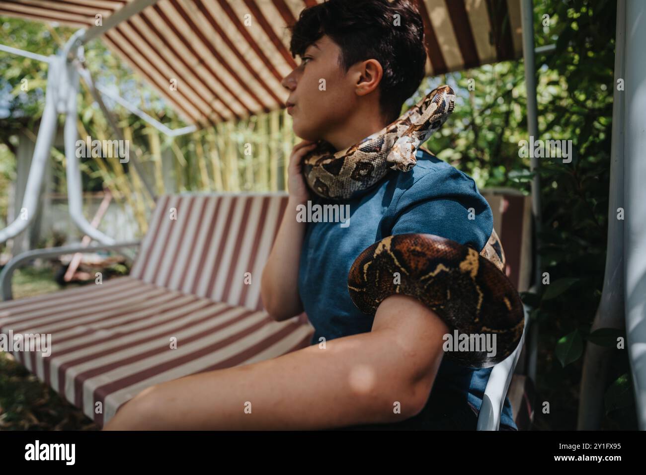 Young girl interacting with snakes in a sunny garden setting Stock ...