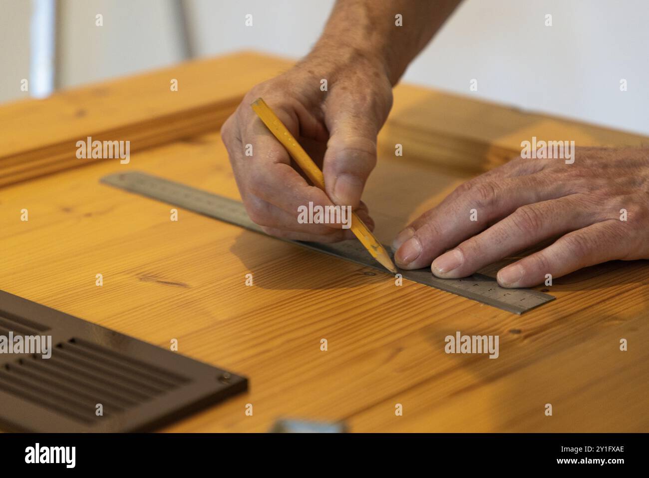 Hands using a ruler and drawing lines on wood in close-up Stock Photo ...