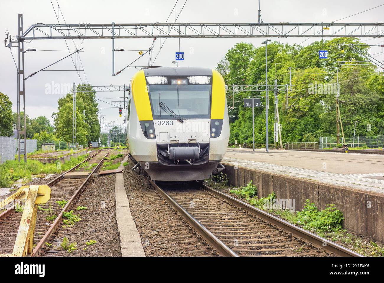 Commuter train at a platform on its way into a railway station, Sweden ...