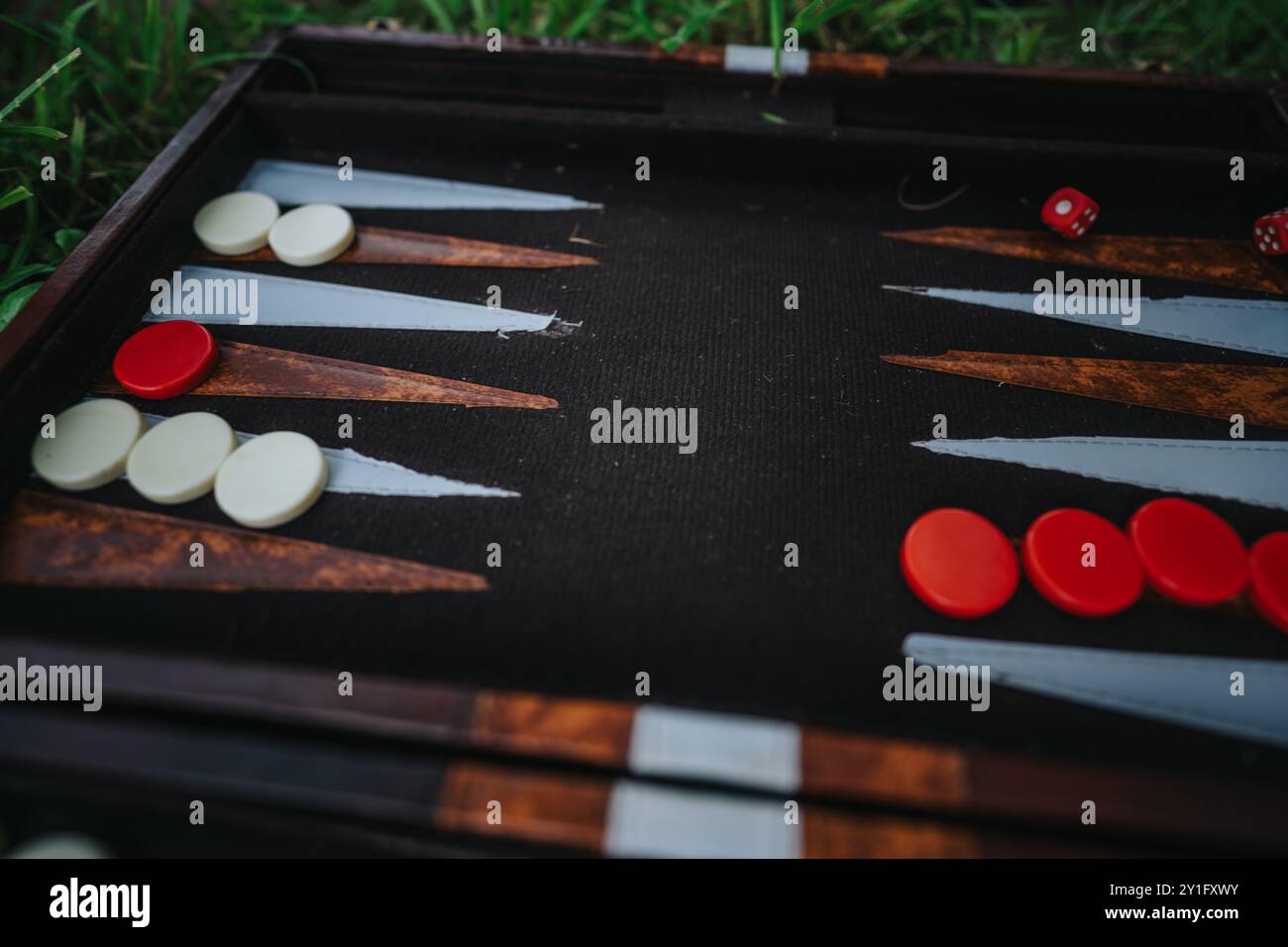 Backgammon board with red and white pieces in a garden setting Stock ...
