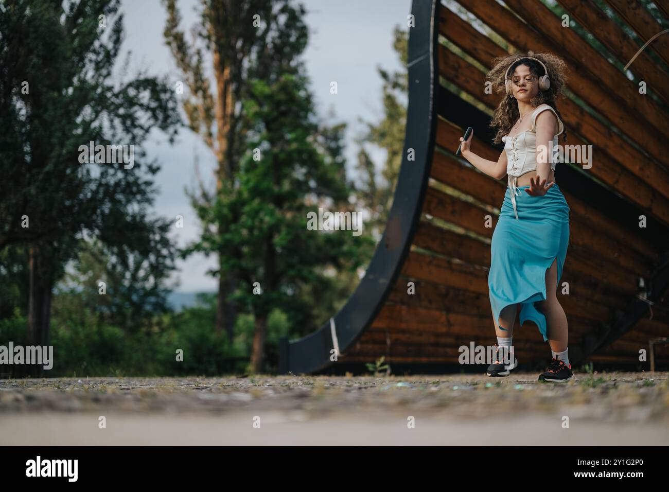 Young woman dancing gracefully in a green park, showcasing modern dance ...
