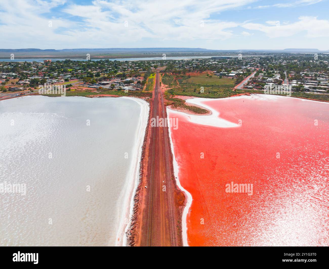 Aerial view of a railway line running through a salt lake coloured ...
