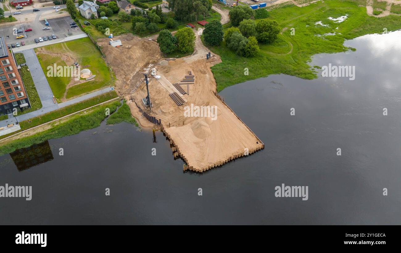 Aerial view of a construction site by a river, featuring a sandy area ...