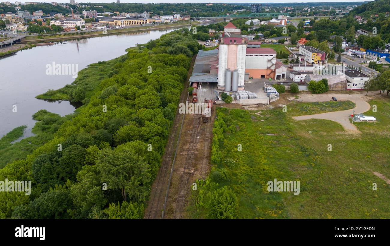 Aerial view of an industrial area featuring large silos, train tracks ...
