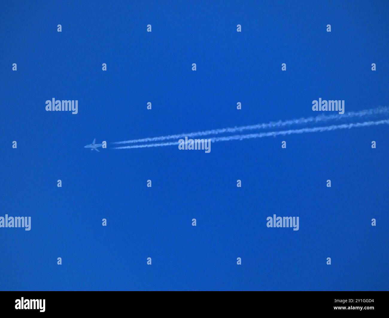 Flugzeug mit Kondensstreifen am blauen Himmel. Ferienflieger ...