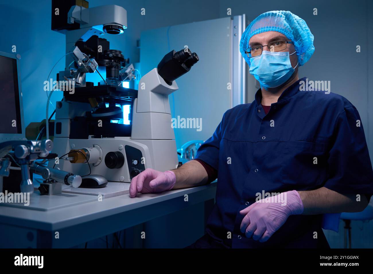 Lab technician sitting near micro-manipulation station Stock Photo - Alamy